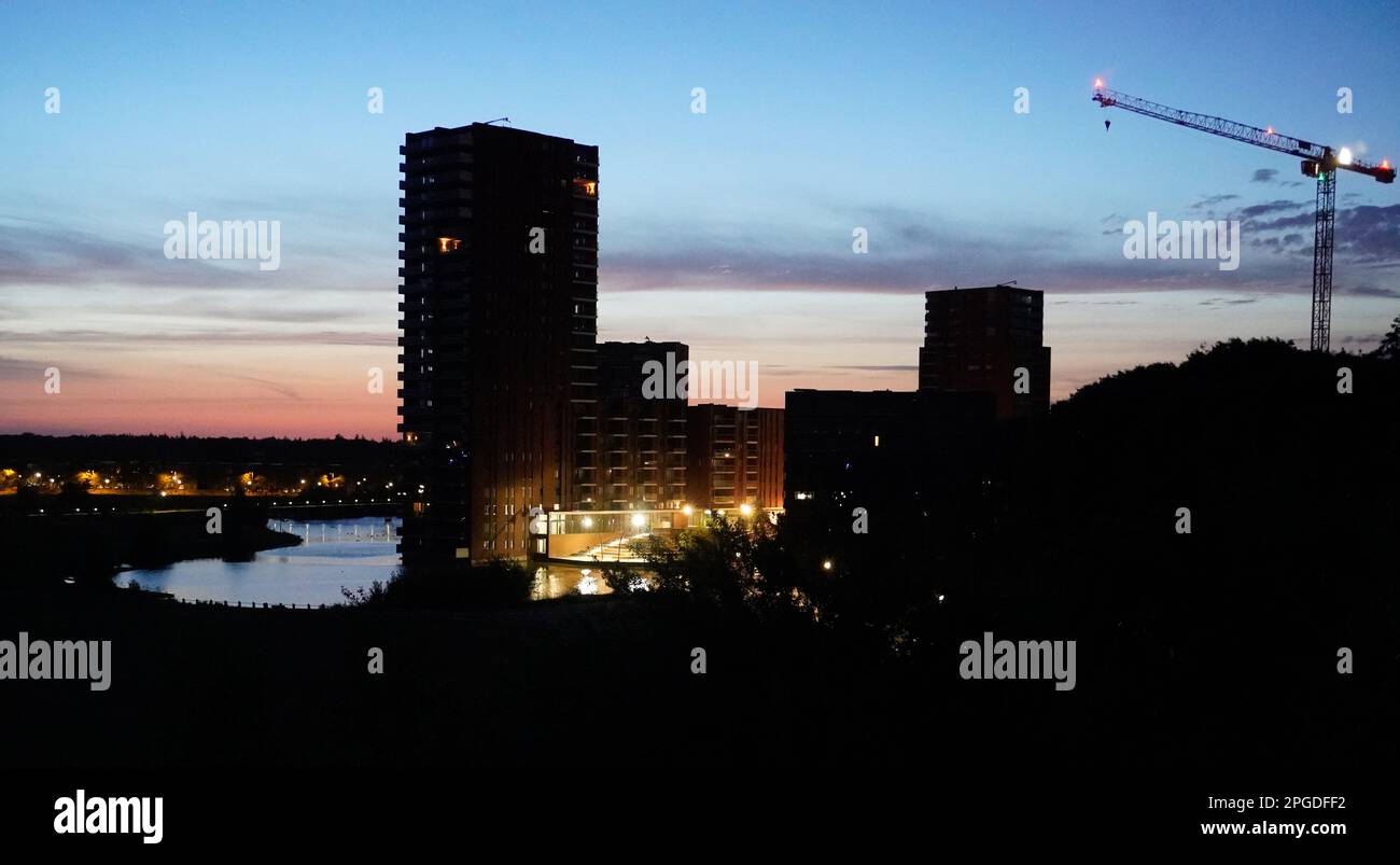 Dutch city buildings during dusk hours with a partially clouded sky ...