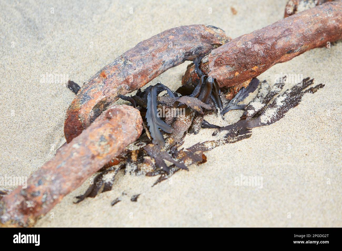 Mousehole, Cornwall, UK - old rusty chain half buried in sand of low ...