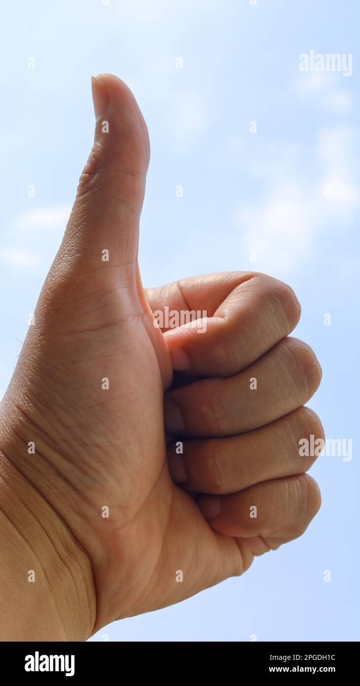 hand sign thumbs up with sky and clouds background Stock Photo - Alamy
