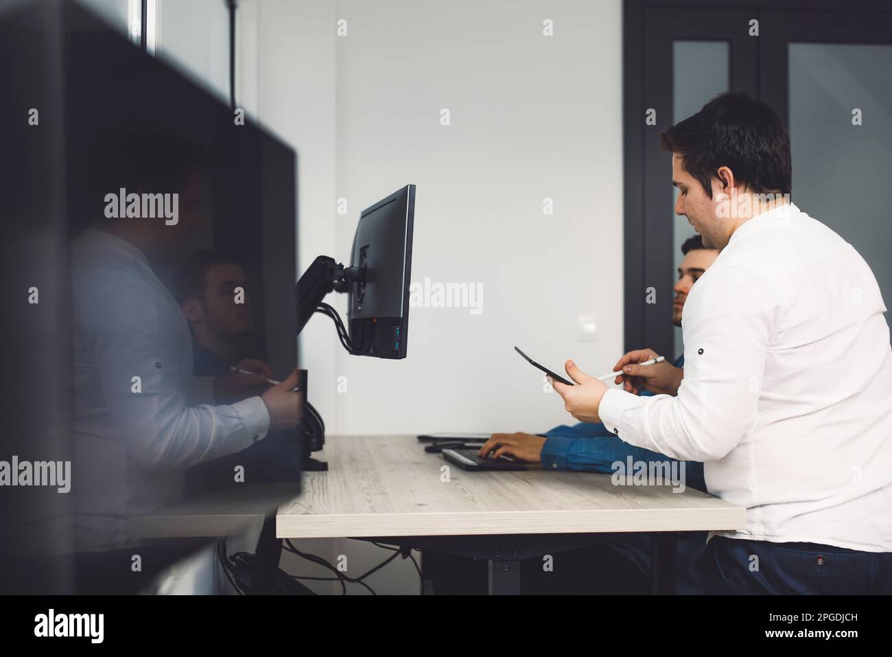 Side view of two colleagues working on a project together developing a ...