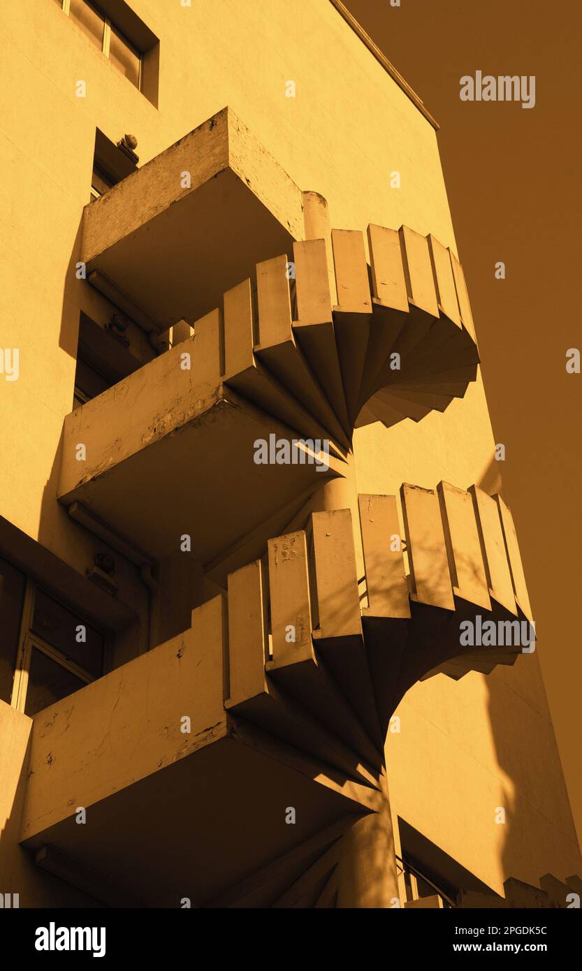 Fire escape spiral stone stairs on a building. Urban architecture ...