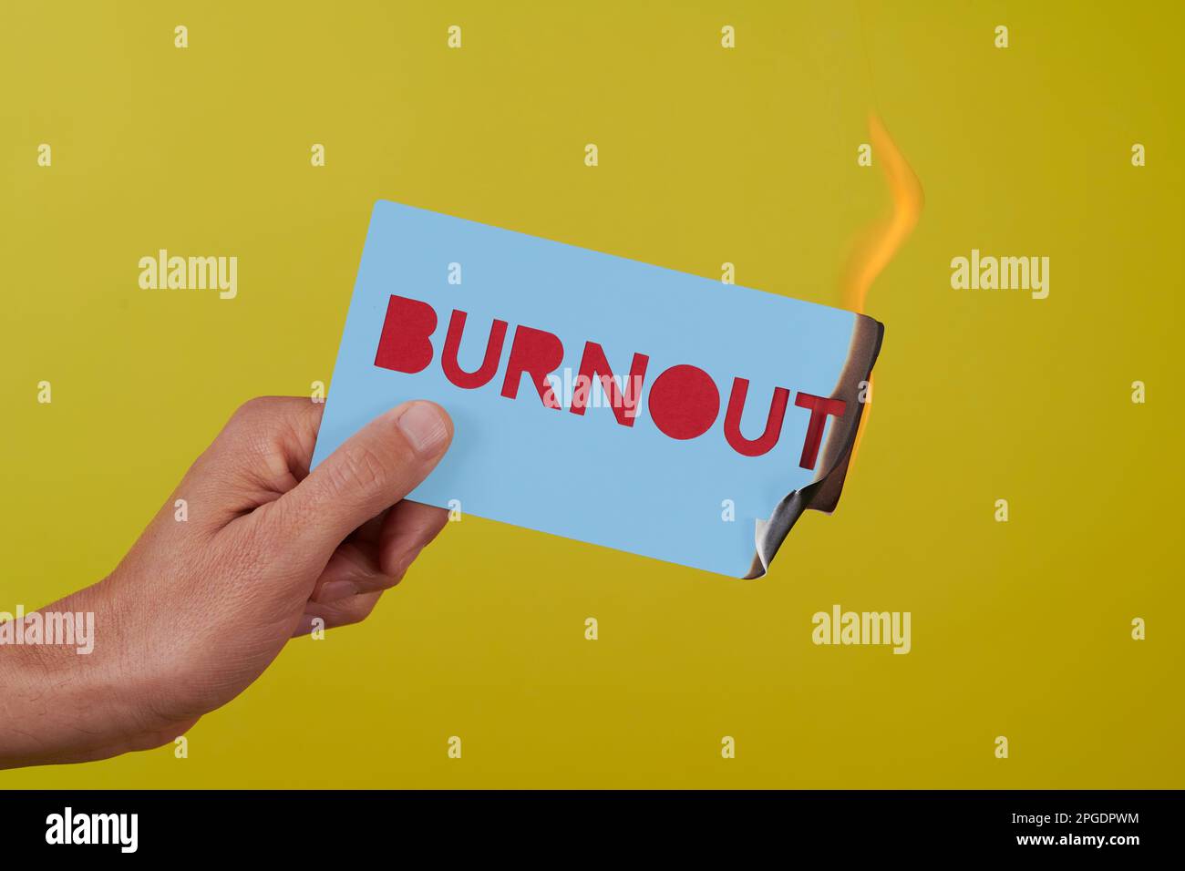 closeup of a man holding a blue sign on fire with the text burnout on a ...