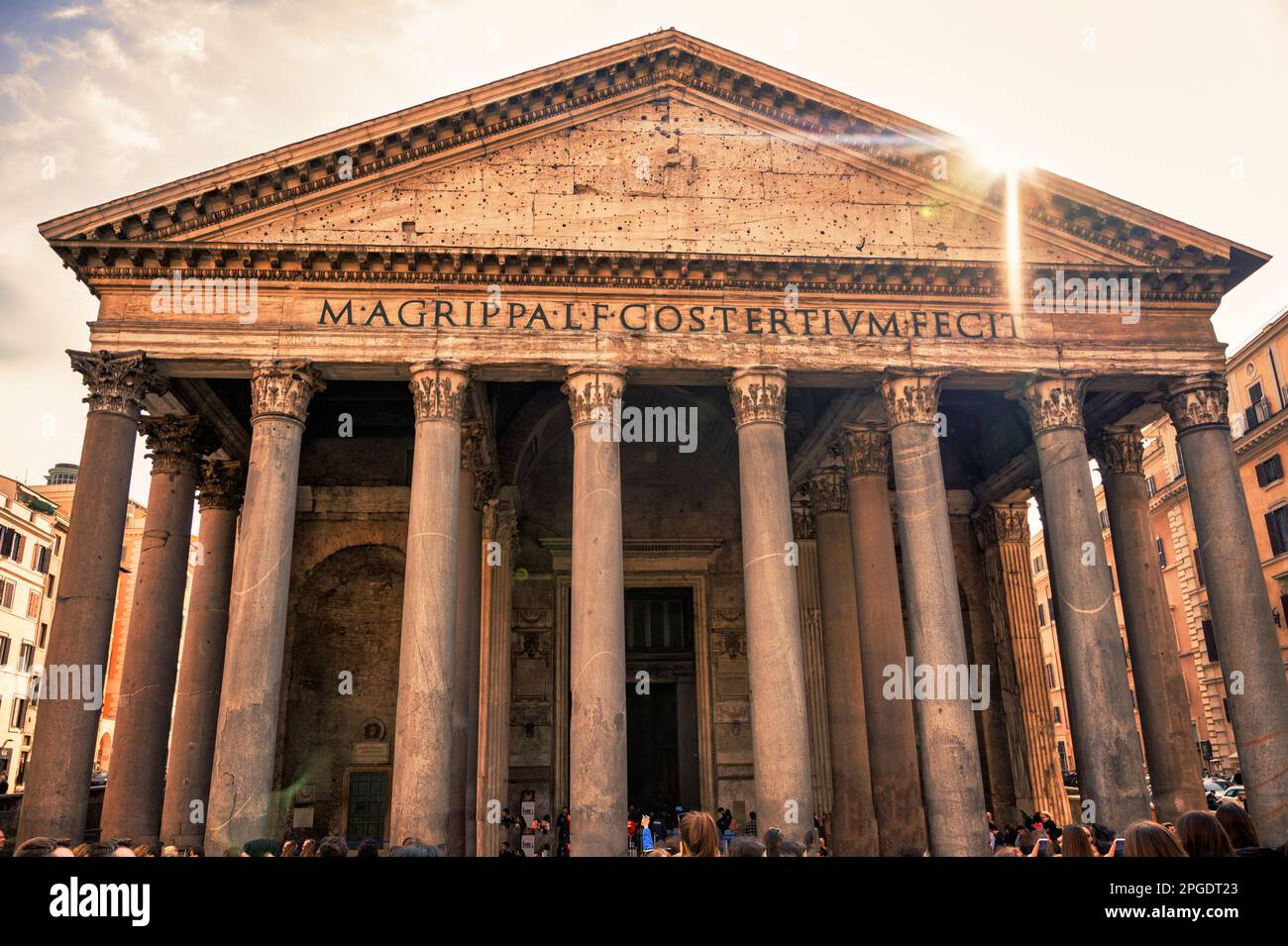 A diverse group of people posing outside an historic building with tall ...