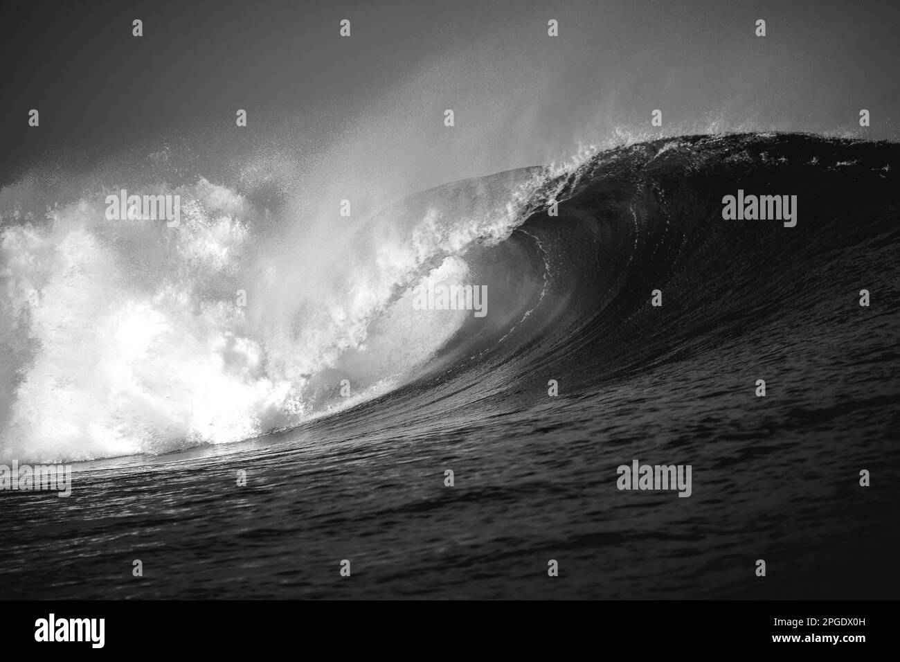 a grayscale powerful wave crashing towards the shore, its white foam ...