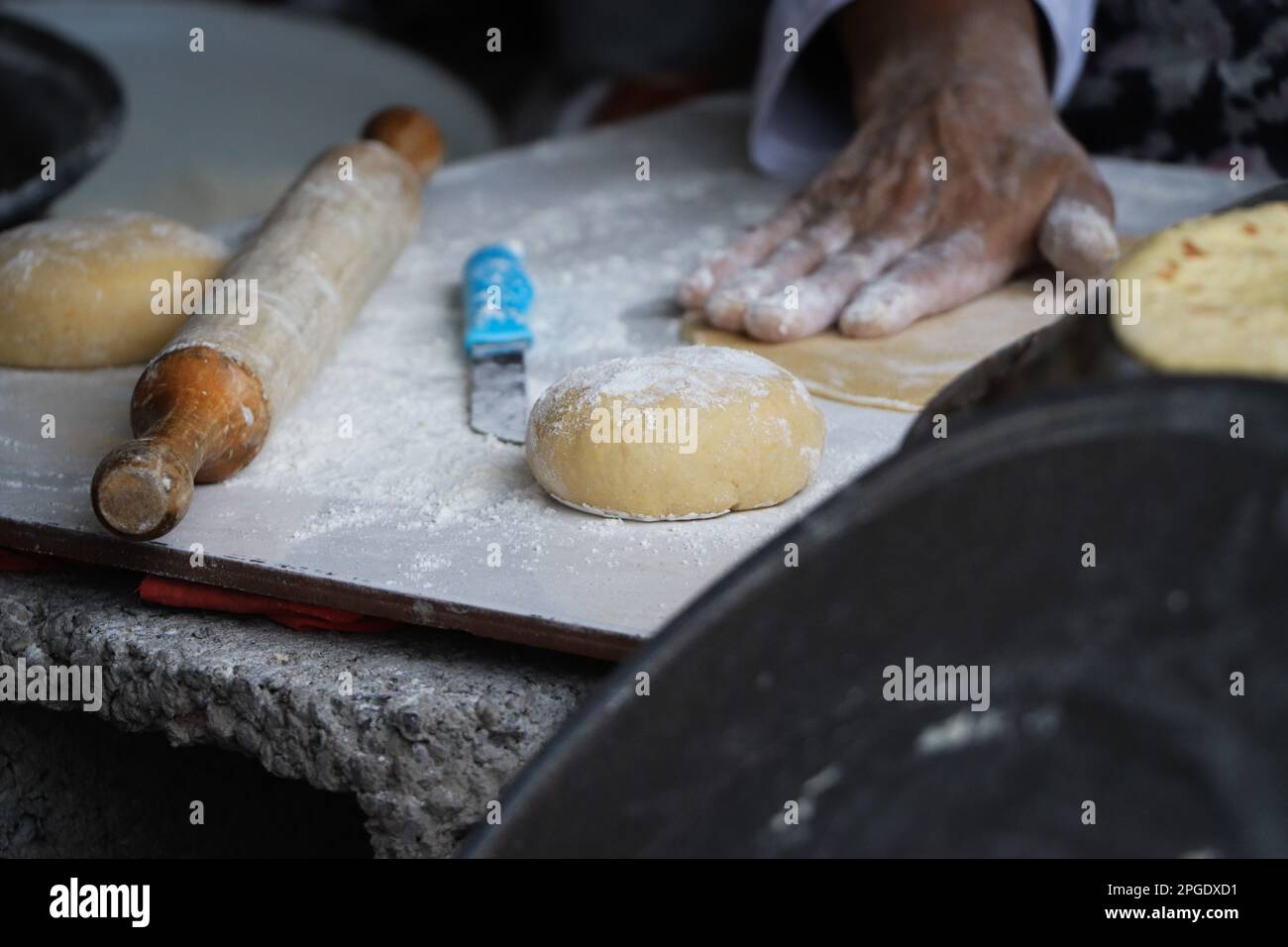 A person is preparing a homemade meal using traditional techniques ...