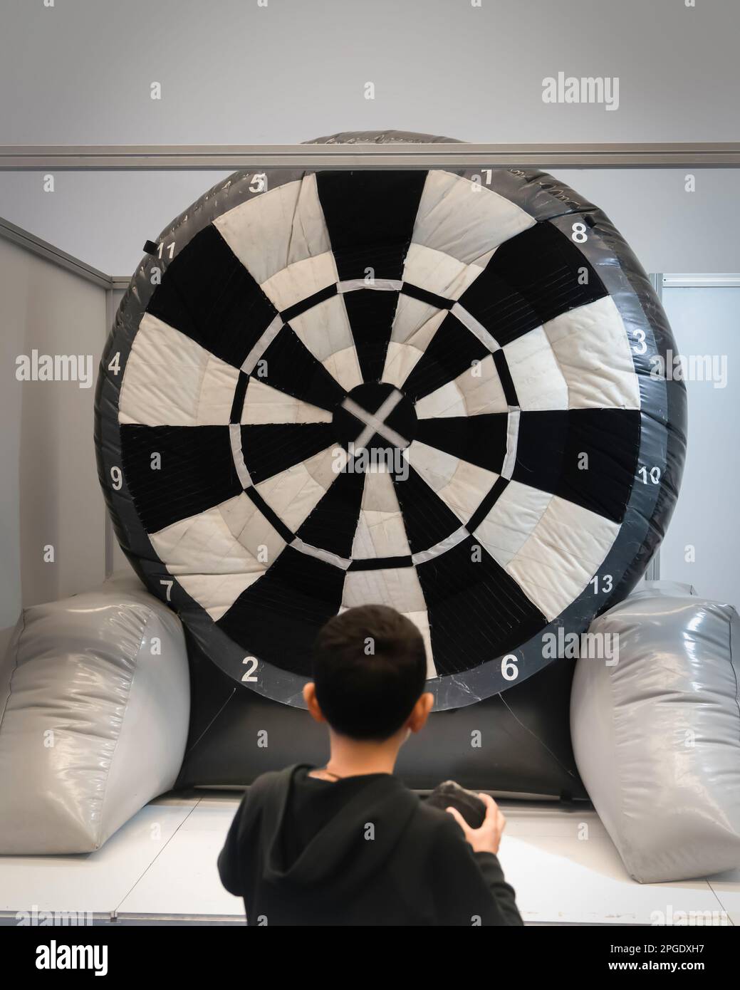 Back view of boy having fun with giant inflatable dart board Stock ...