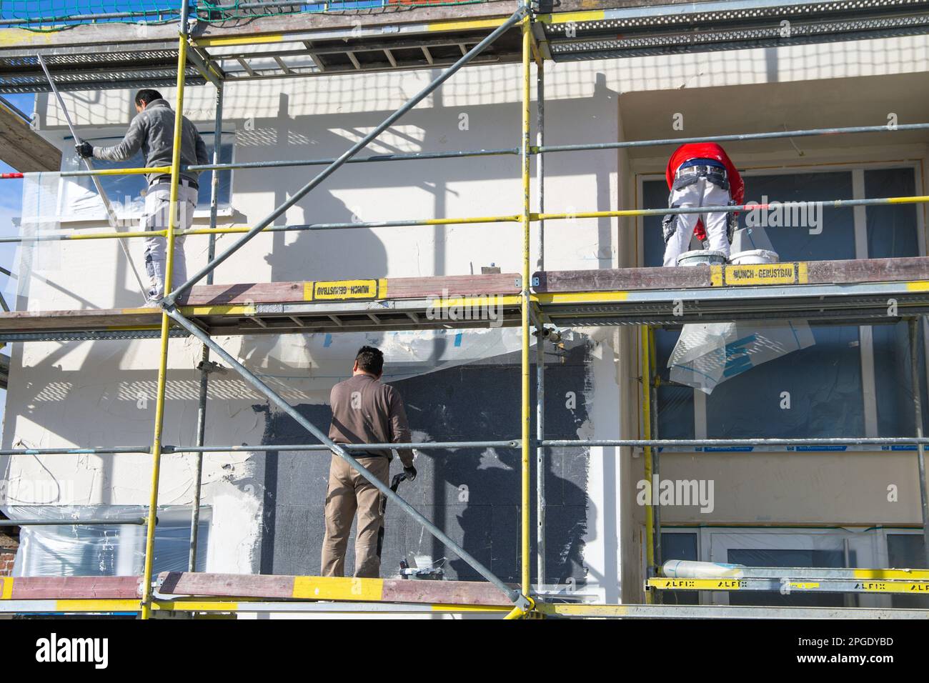 Plasterers plaster the facade of a new building Stock Photo - Alamy