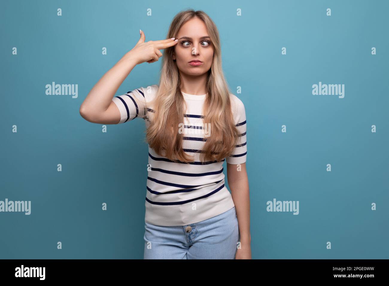 cute girl in casual clothes shows a finger to the head gesture on a ...
