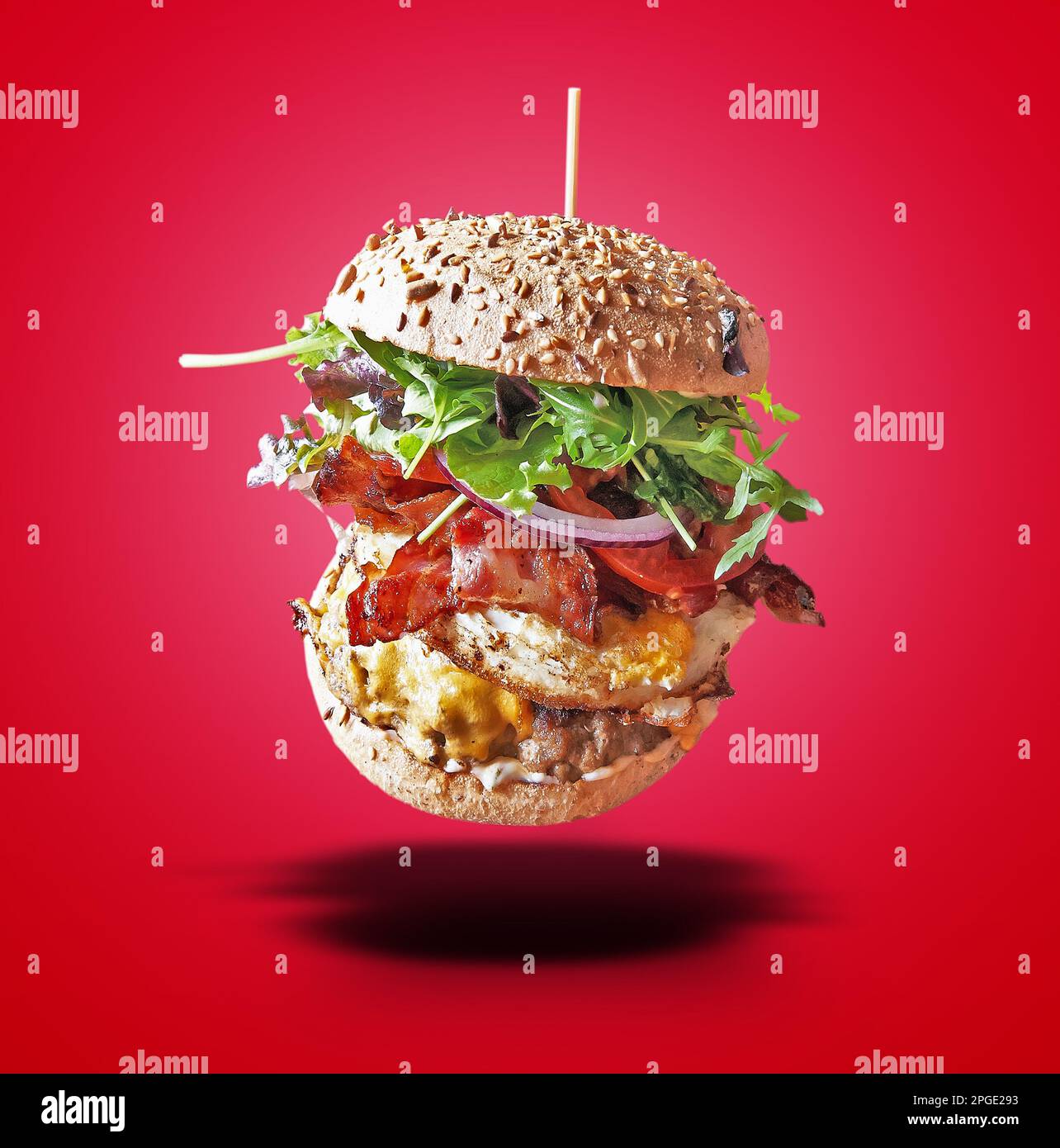 Floating Big burger flying on red gradient background Stock Photo - Alamy