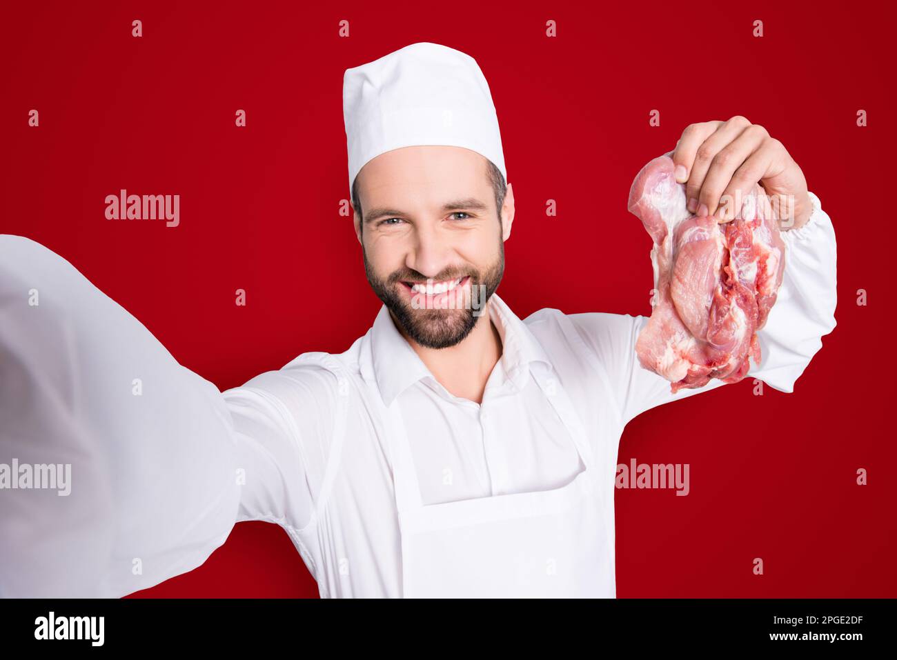 Self portrait of successful joyful butcher with stubble shooting selfie ...