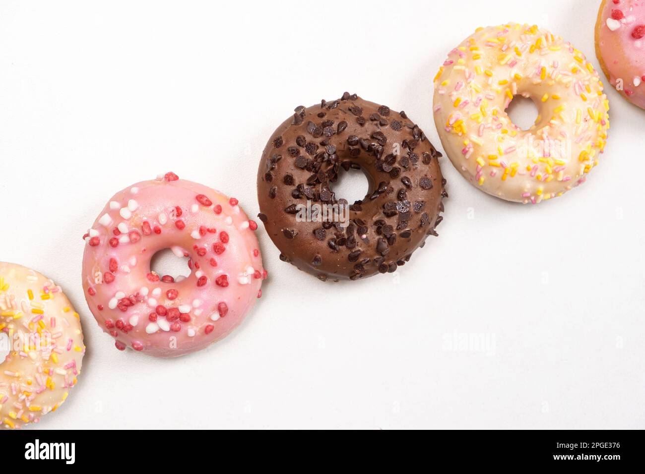Five donuts in a row - white, pink and chocolate on a white background ...