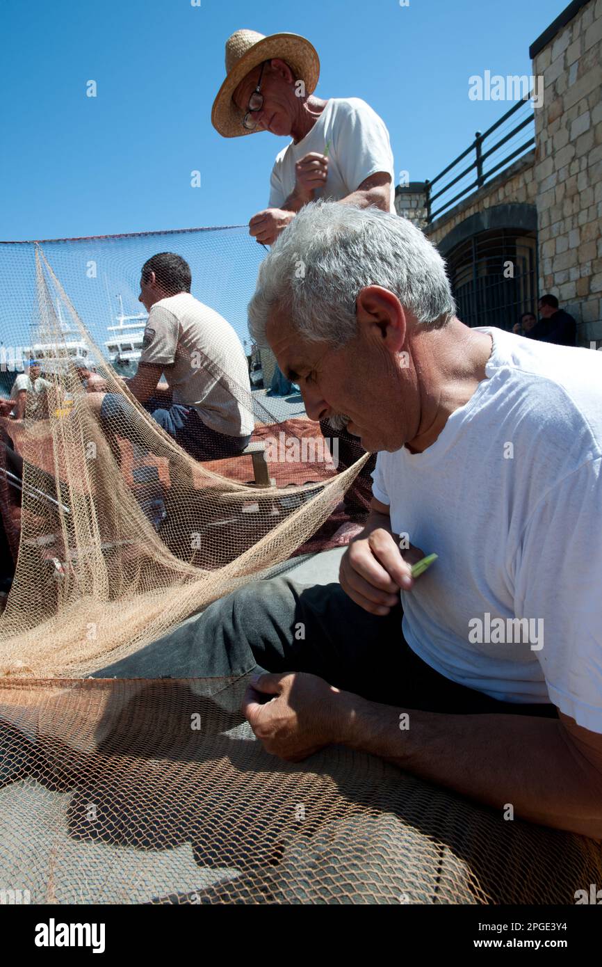 Pescatori che riparano le reti da pesca hi-res stock photography and ...