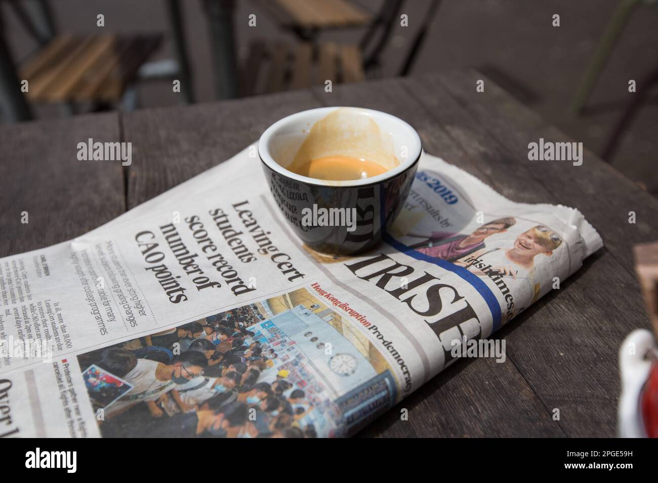 Cup of freshly brewed espresso on Irish Independent newspaper. Wooden ...