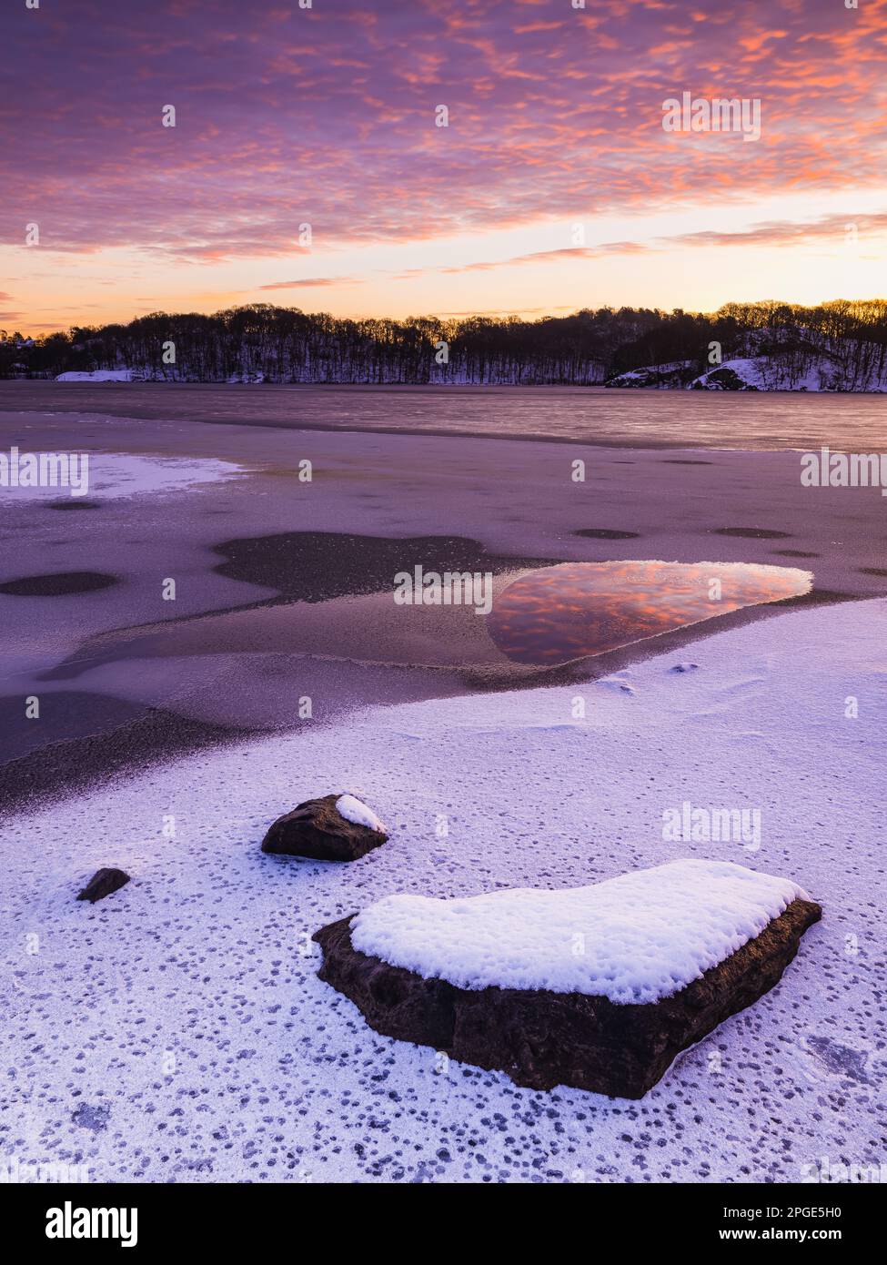 A breathtaking sunrise creates a tranquil scene of ice-covered water ...
