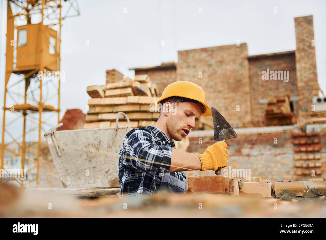 Laying bricks. Construction worker in uniform and safety equipment have ...