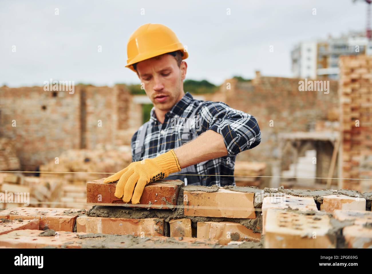 Laying bricks. Construction worker in uniform and safety equipment have ...
