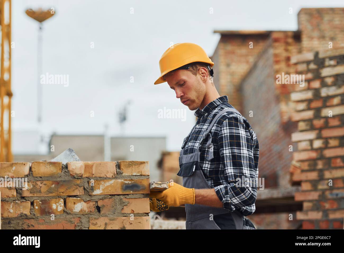 With level measuring tool. Construction worker in uniform and safety ...