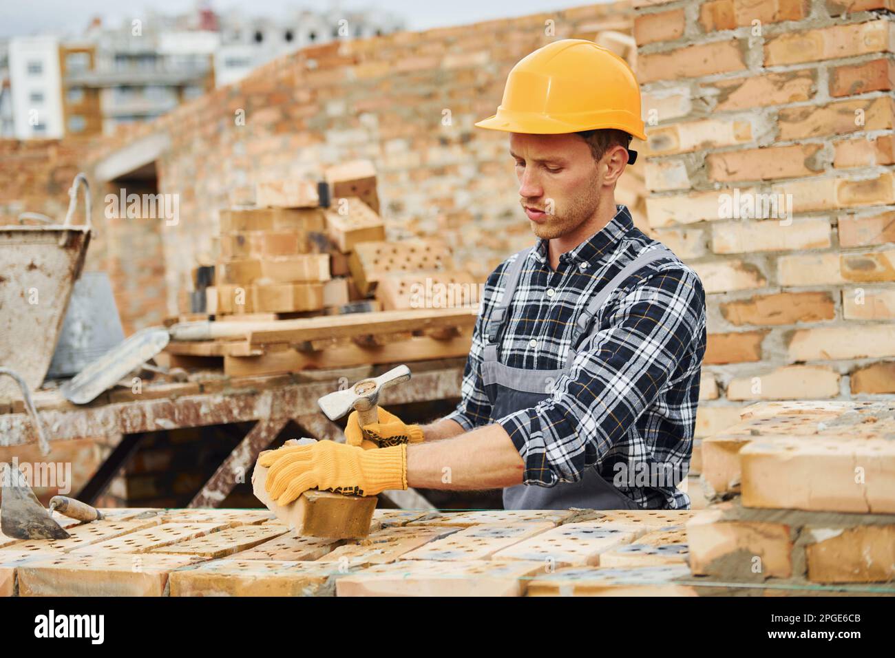 Laying bricks. Construction worker in uniform and safety equipment have ...