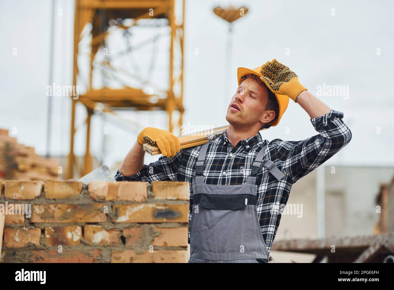 Holds measuring tool and takes break. Construction worker in uniform ...