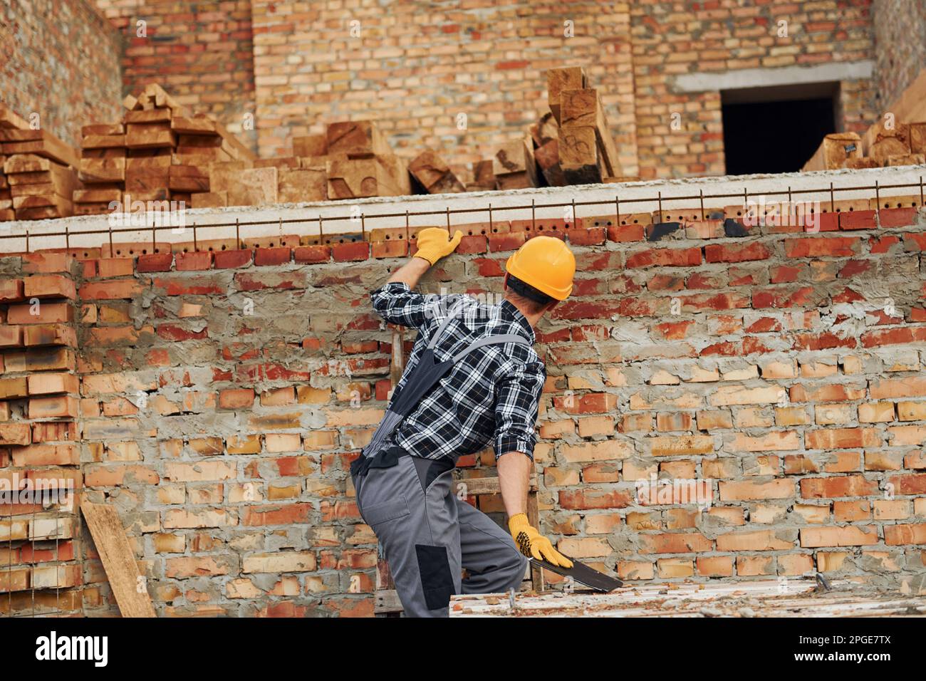Climbs up. Construction worker in uniform and safety equipment have job ...