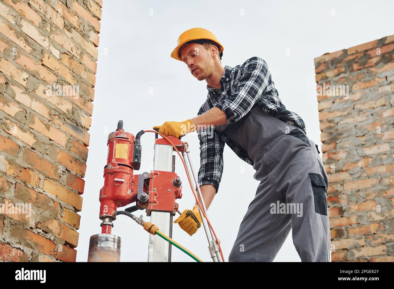 Uses blending drill. Construction worker in uniform and safety ...