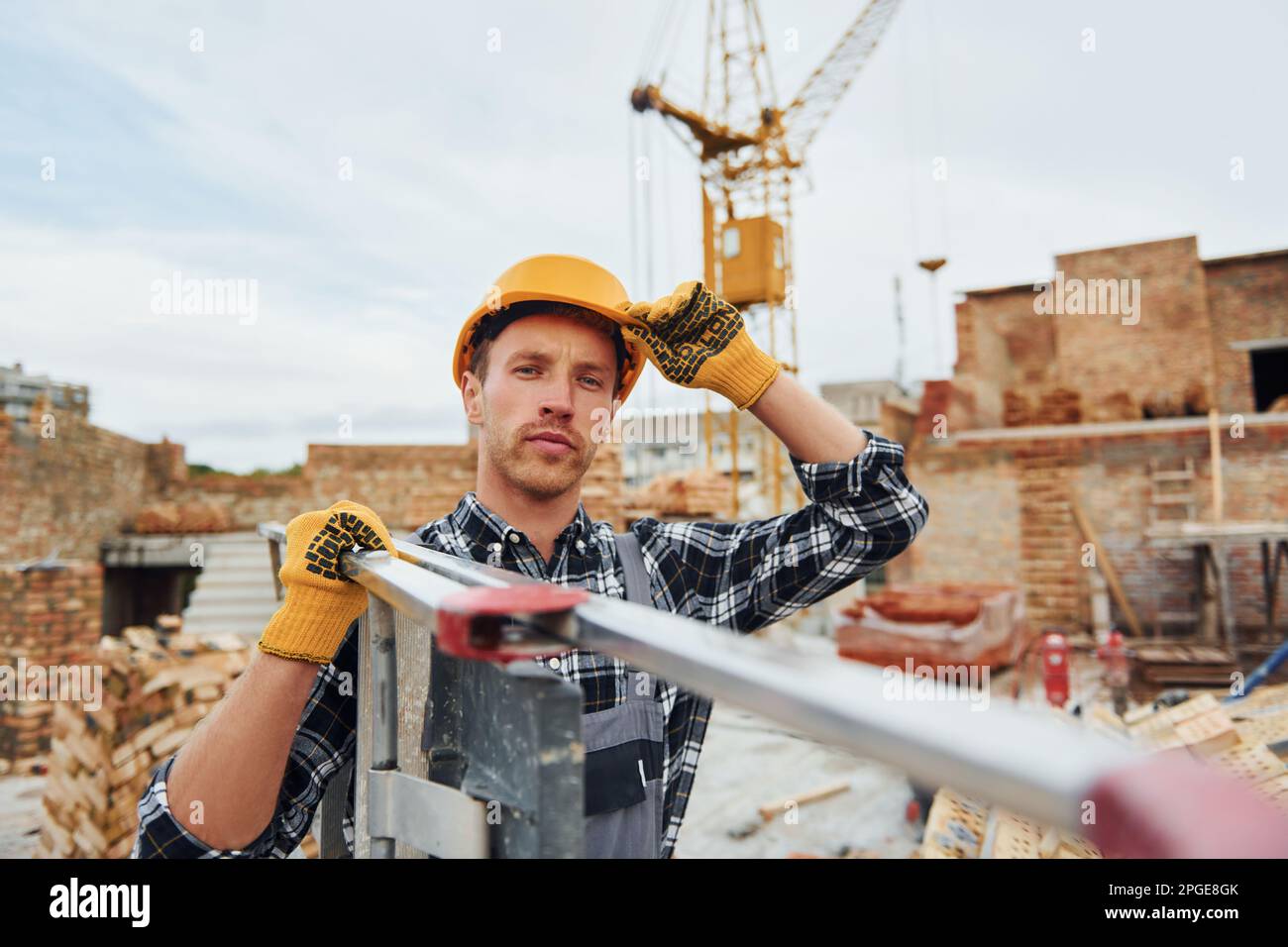 Ladder in hands. Construction worker in uniform and safety equipment ...
