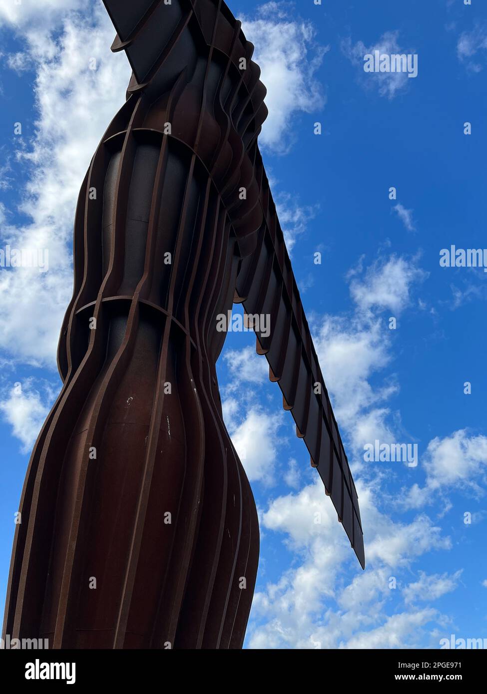 A metal sculpture of an angel with outstretched wings standing in a ...