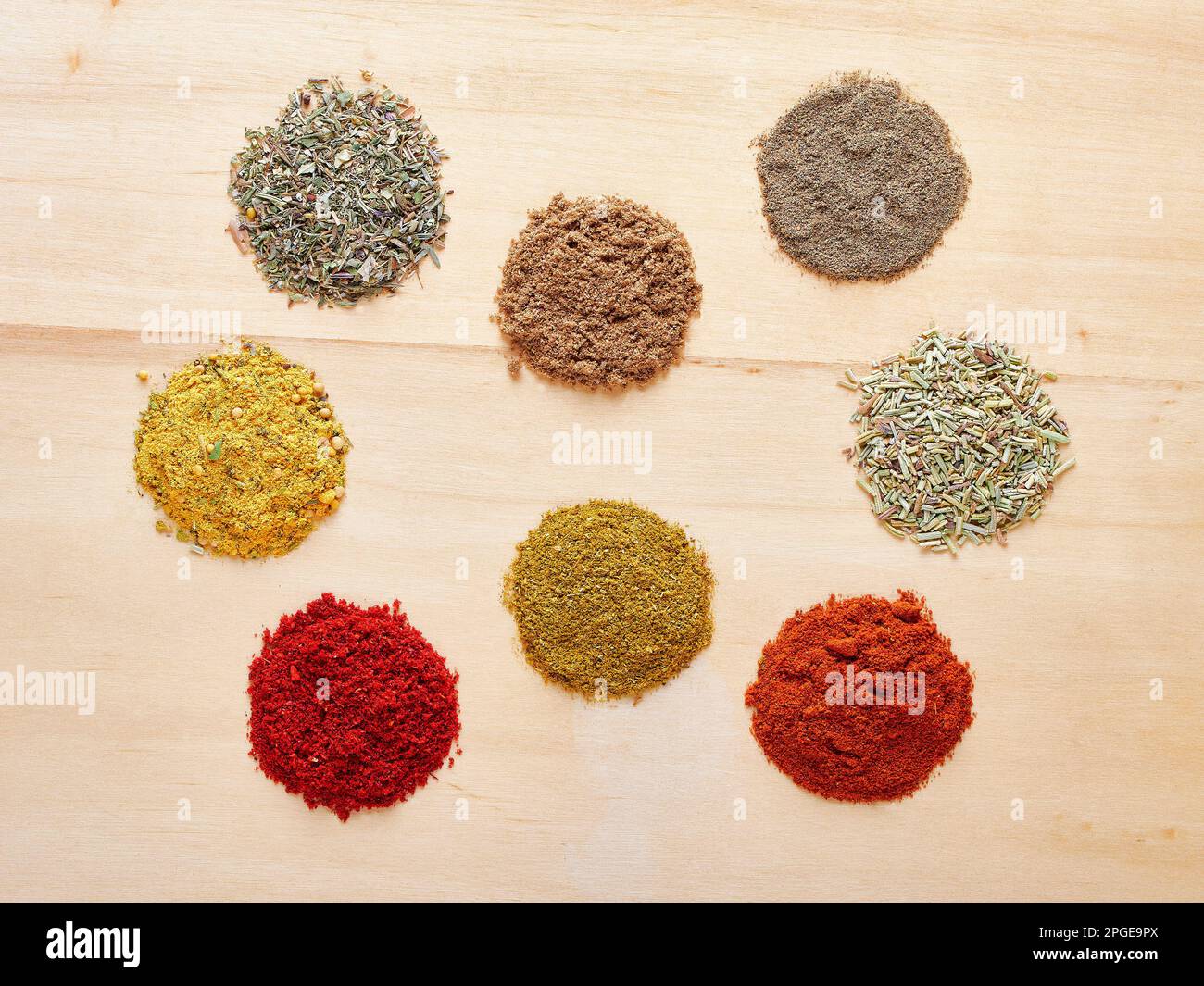 Spices circles 8 pieces on a wooden background. Garlic, coriander, for ...