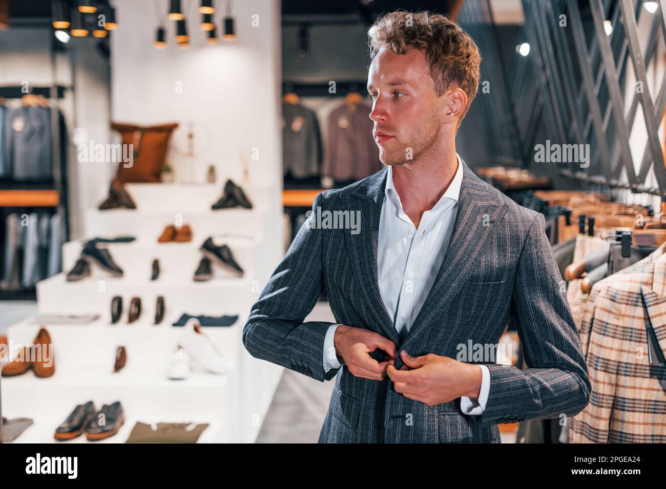 Shopping day. Young guy in modern store with new clothes. Elegant ...
