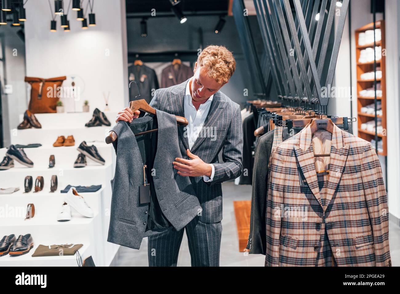 Shopping day. Young guy in modern store with new clothes. Elegant ...