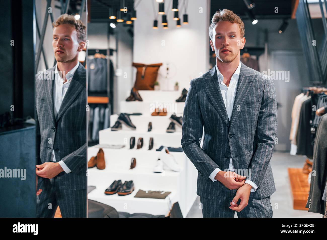 Shopping day. Young guy in modern store with new clothes. Elegant ...