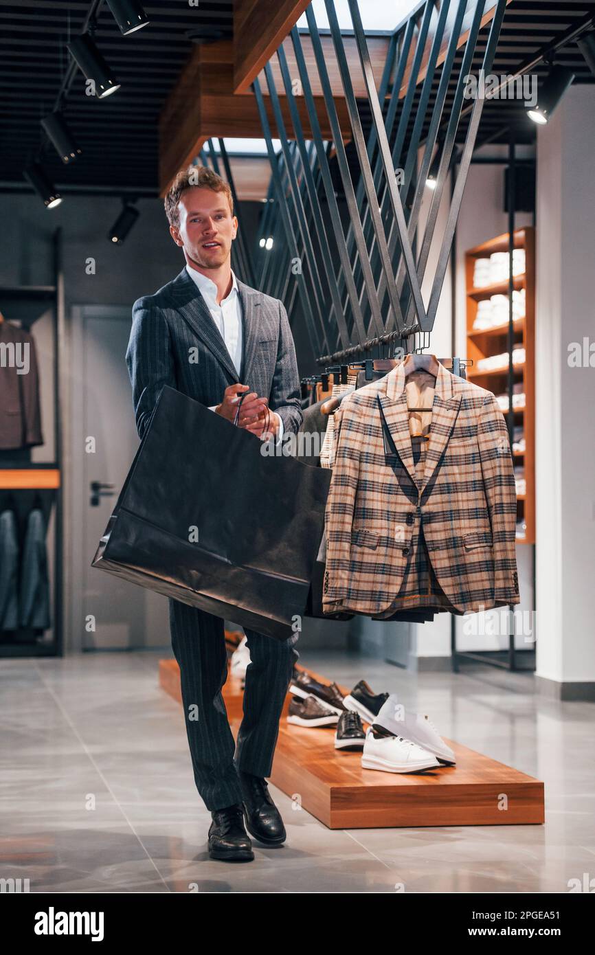 Shopping day. Young guy in modern store with new clothes. Elegant ...
