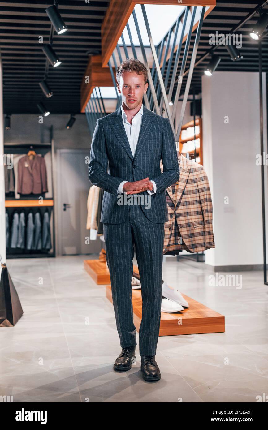 Shopping day. Young guy in modern store with new clothes. Elegant ...