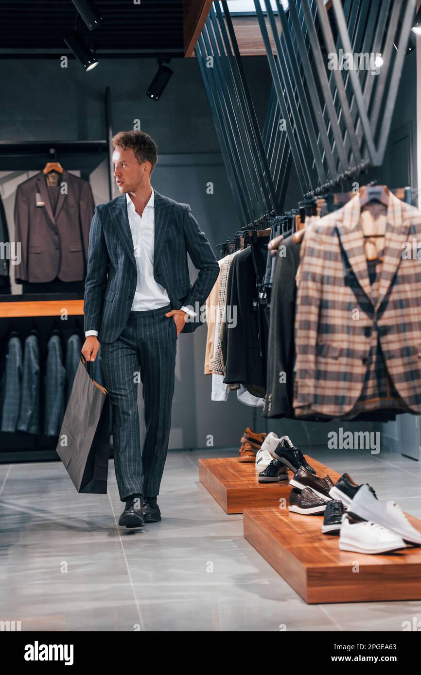 Shopping day. Young guy in modern store with new clothes. Elegant ...