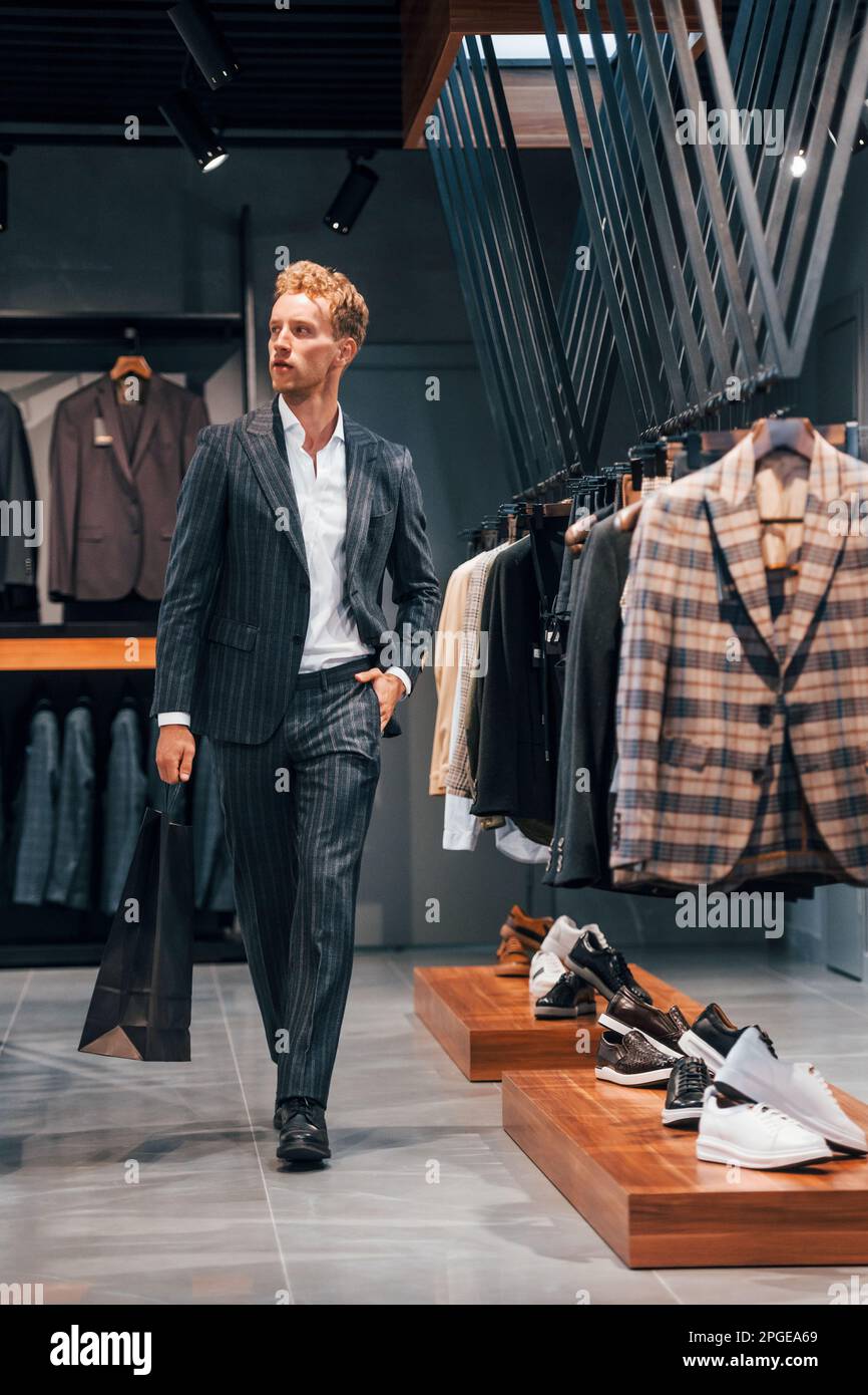 Shopping day. Young guy in modern store with new clothes. Elegant ...