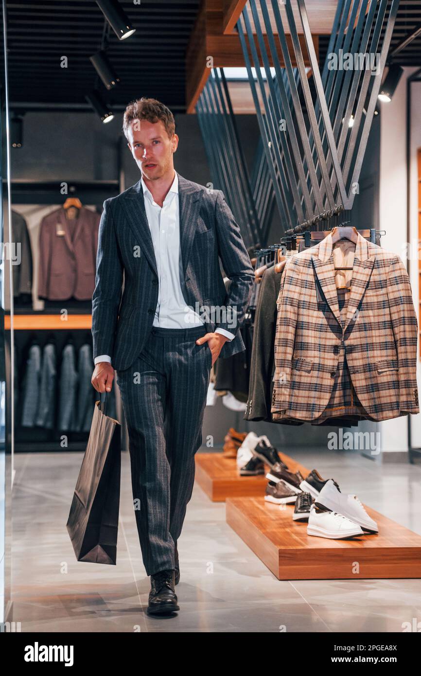 Shopping day. Young guy in modern store with new clothes. Elegant ...