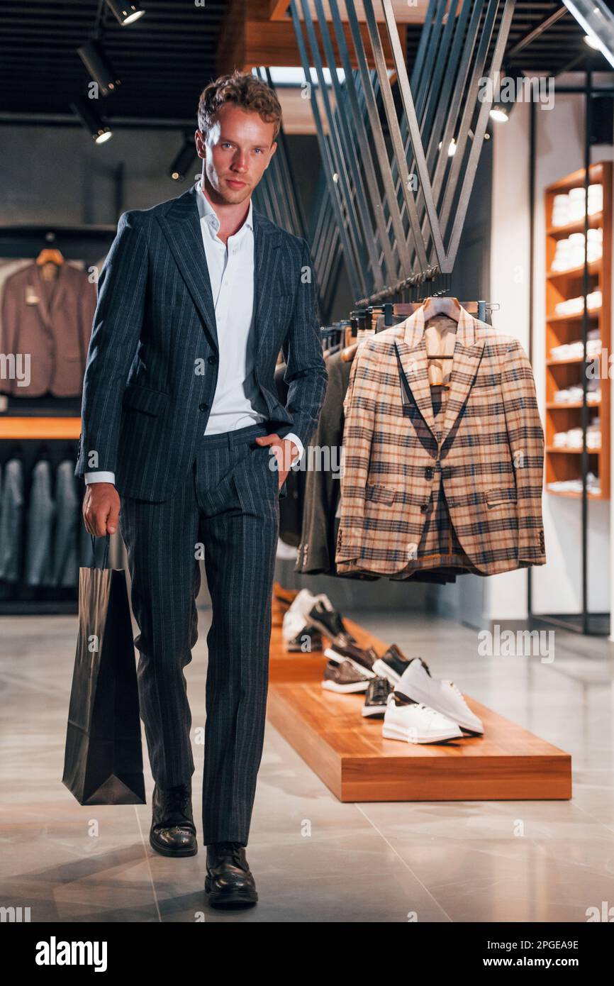 Shopping day. Young guy in modern store with new clothes. Elegant ...