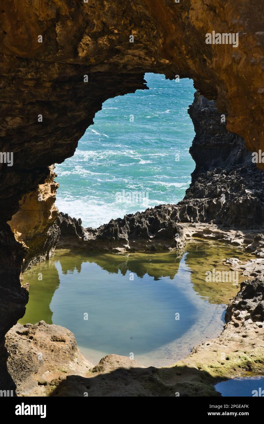 A stunning view of an opening in a cave on the beach, leading to the ...