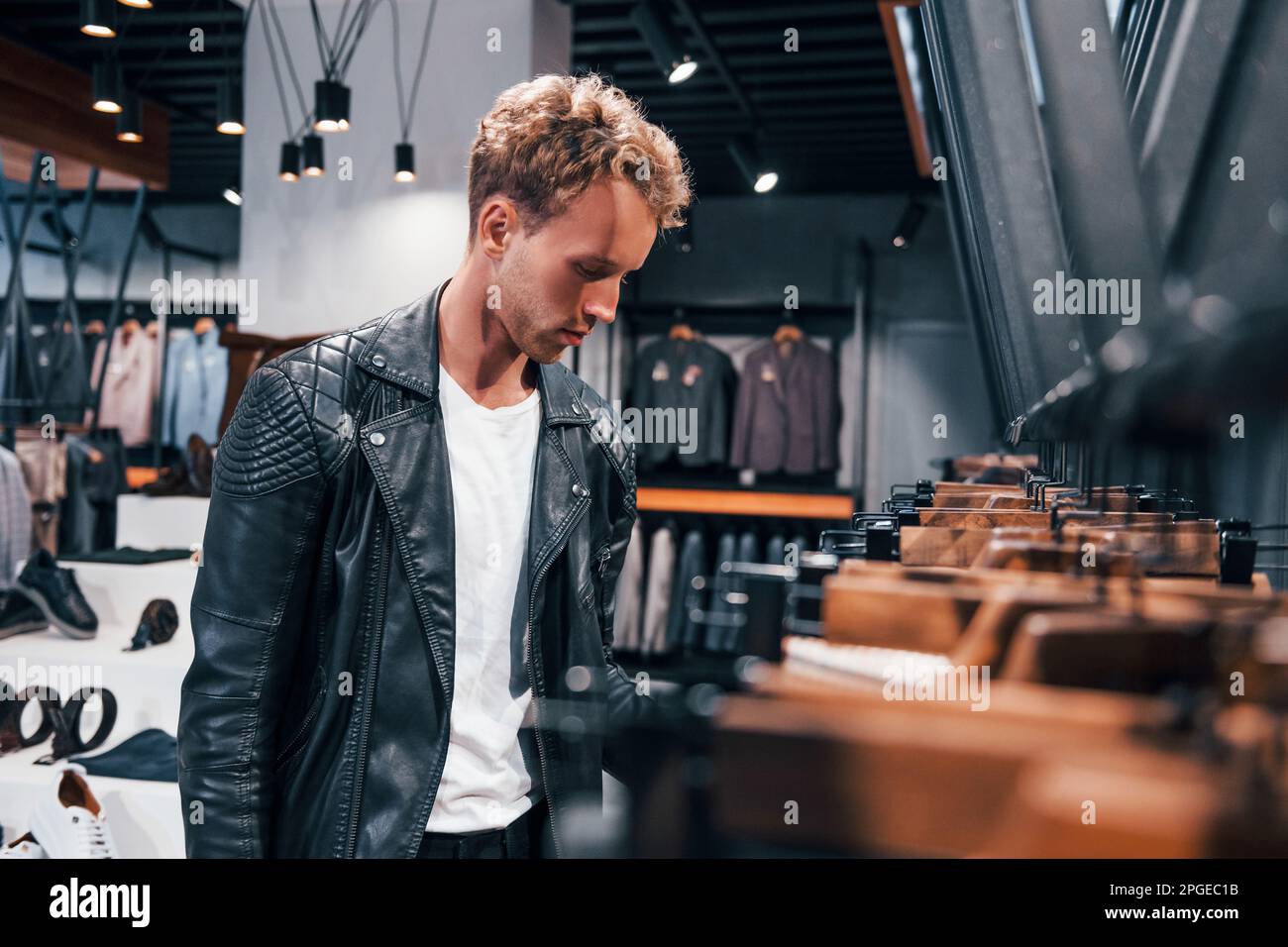 Weekend shopping. Young guy in modern store with new clothes. Elegant ...