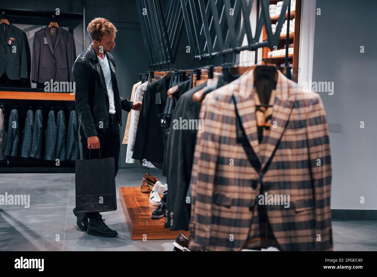 Weekend shopping. Young guy in modern store with new clothes. Elegant ...