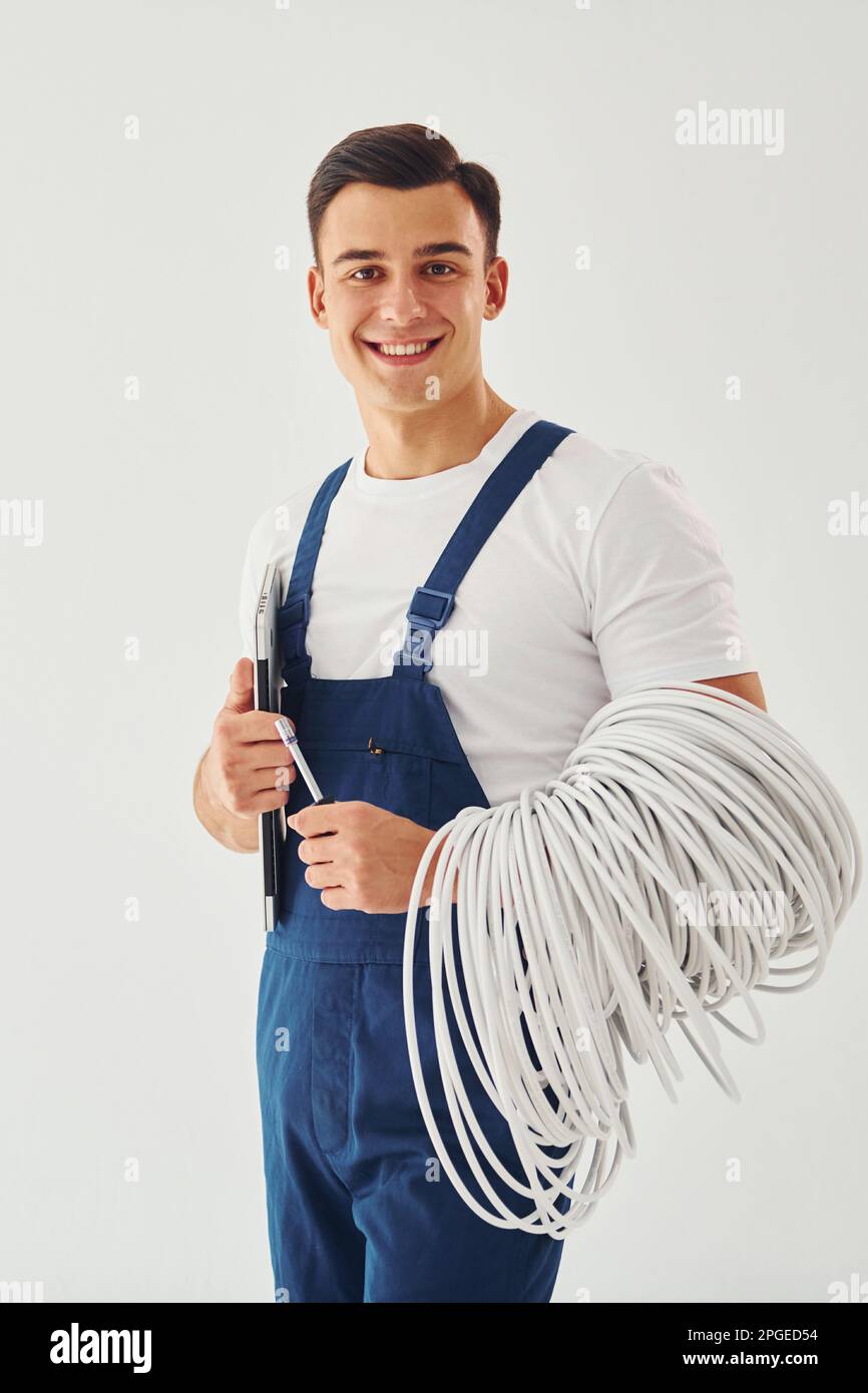 Holds cables, notepad and screwdriver. Male worker in blue uniform ...