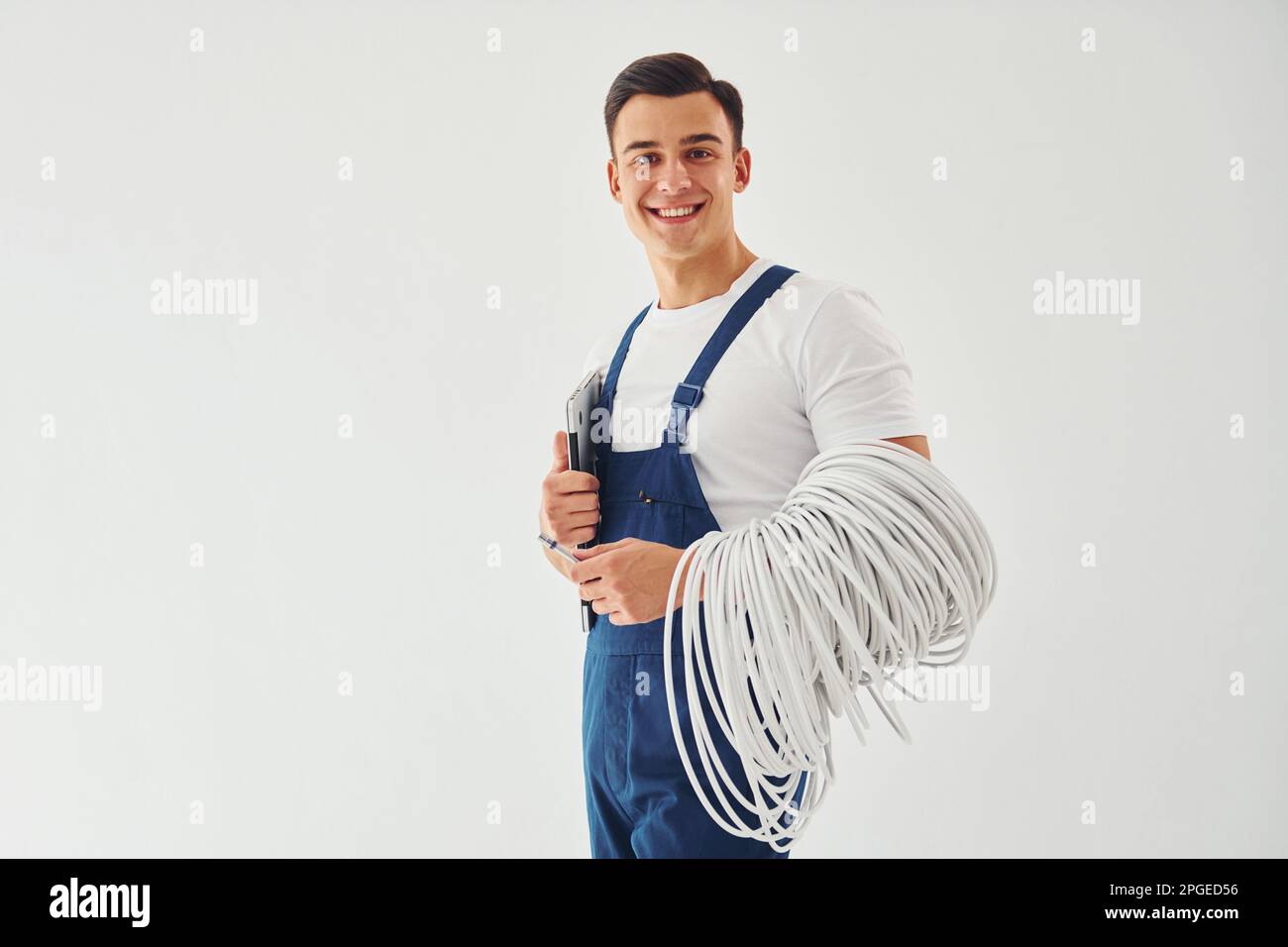 Holds cables, notepad and screwdriver. Male worker in blue uniform ...