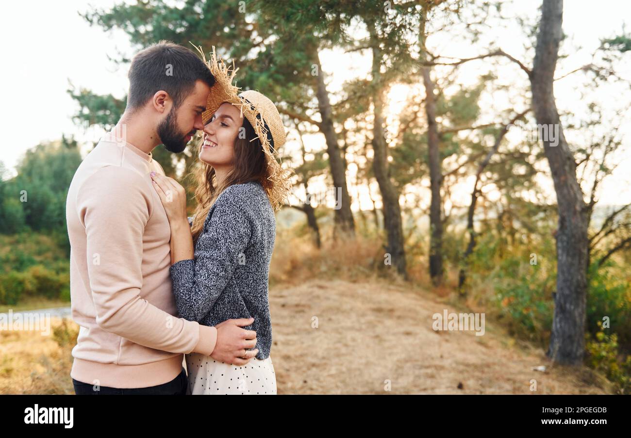 Standing and hugging. Cheerful lovely young couple having a rest ...