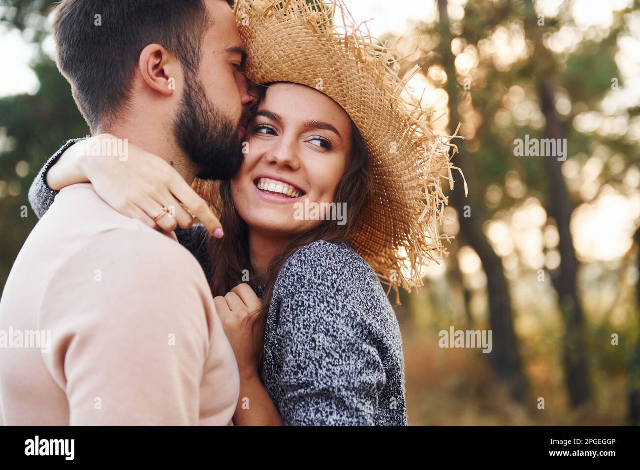 Standing and hugging. Cheerful lovely young couple having a rest ...