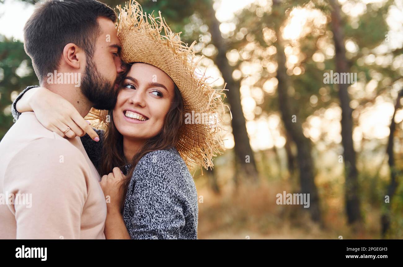 Standing and hugging. Cheerful lovely young couple having a rest ...