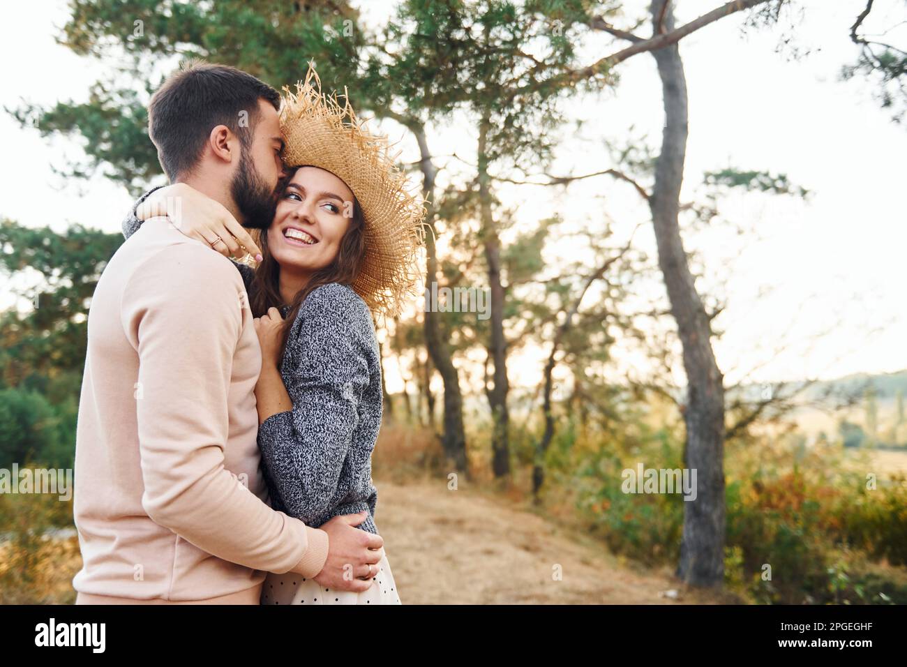 Standing and hugging. Cheerful lovely young couple having a rest ...