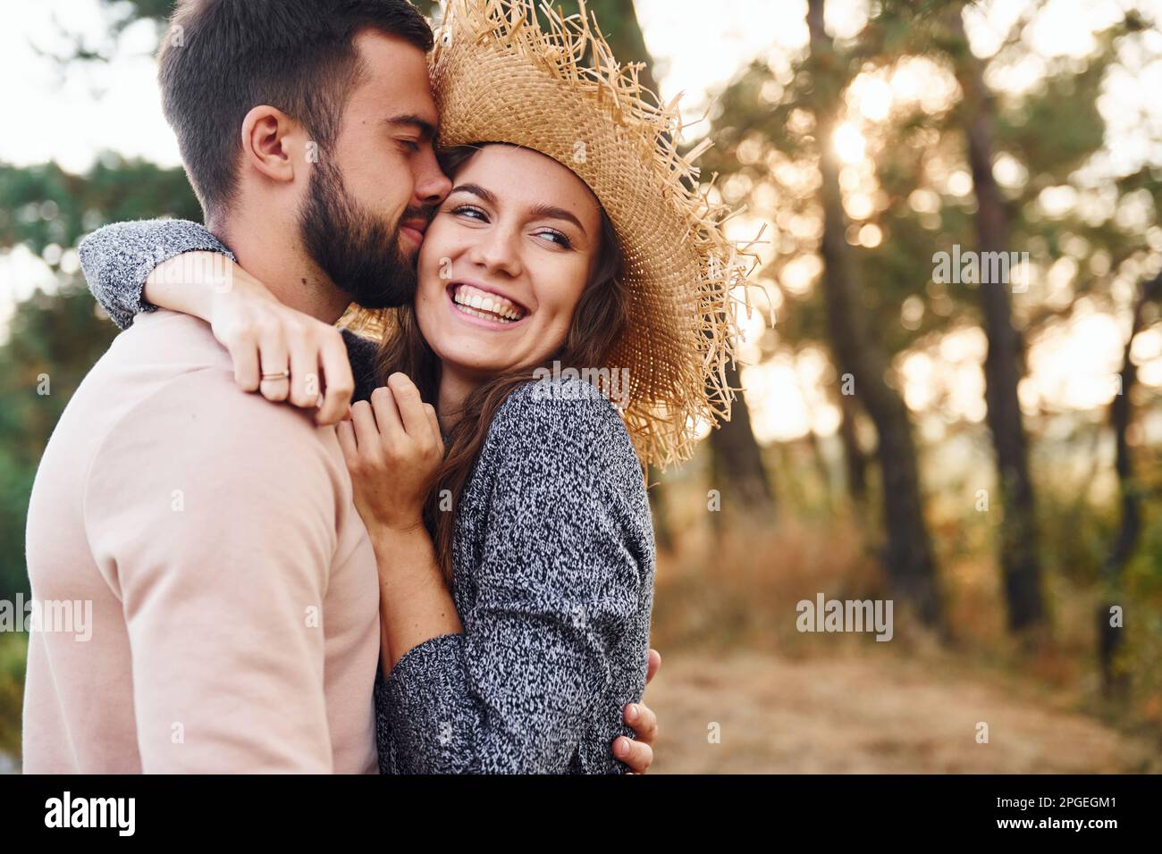 Standing and hugging. Cheerful lovely young couple having a rest ...