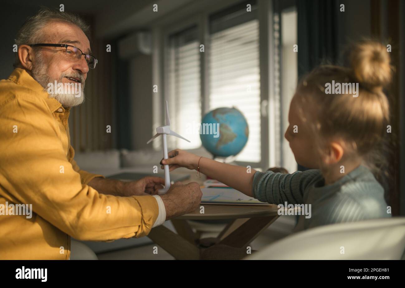 Senior man doing homework with his granddaughter Stock Photo - Alamy