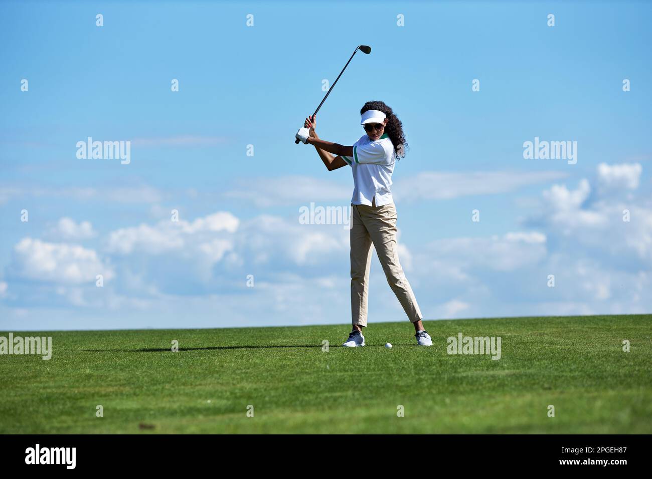 Minimal full length portrait of sporty young woman playing golf on ...