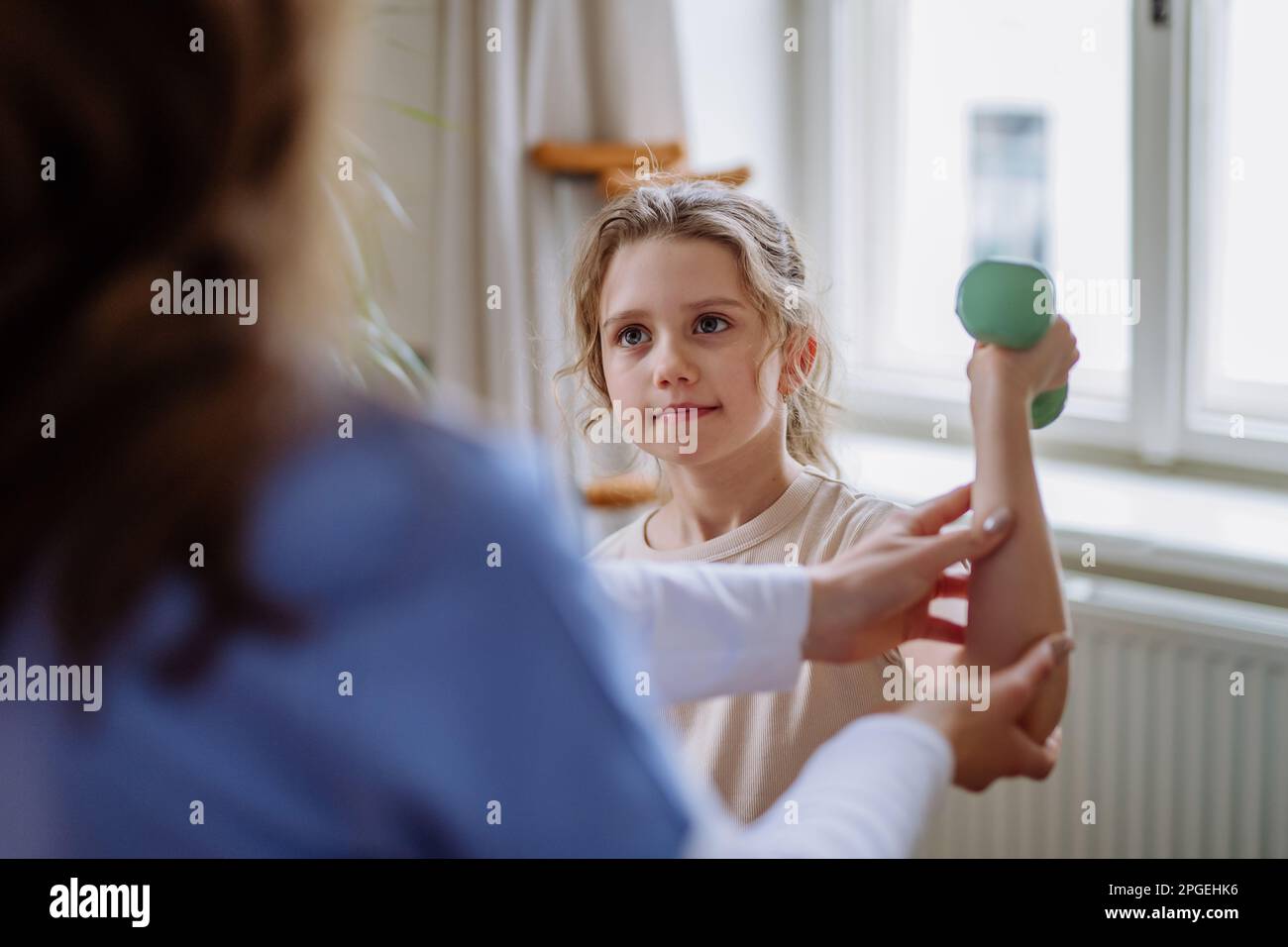 Little girl doing exercise with a nurse Stock Photo - Alamy